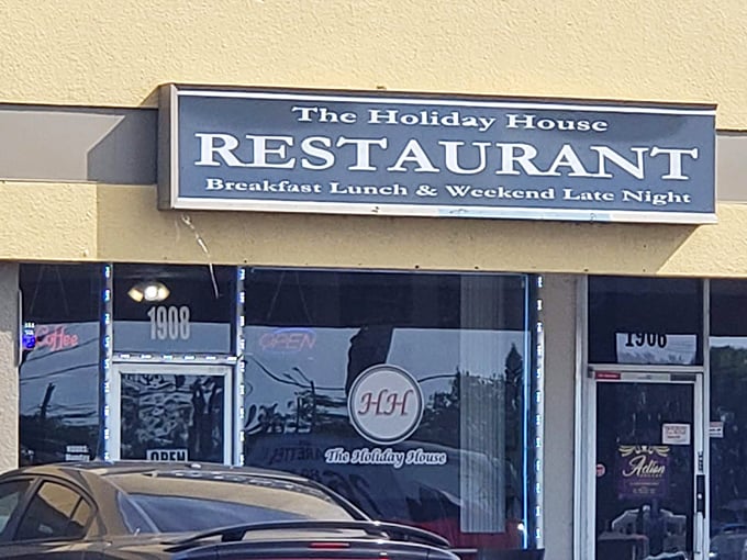The iconic red curtains and "HH" logo welcome hungry travelers like a beacon of comfort food hope in Holiday, Florida.