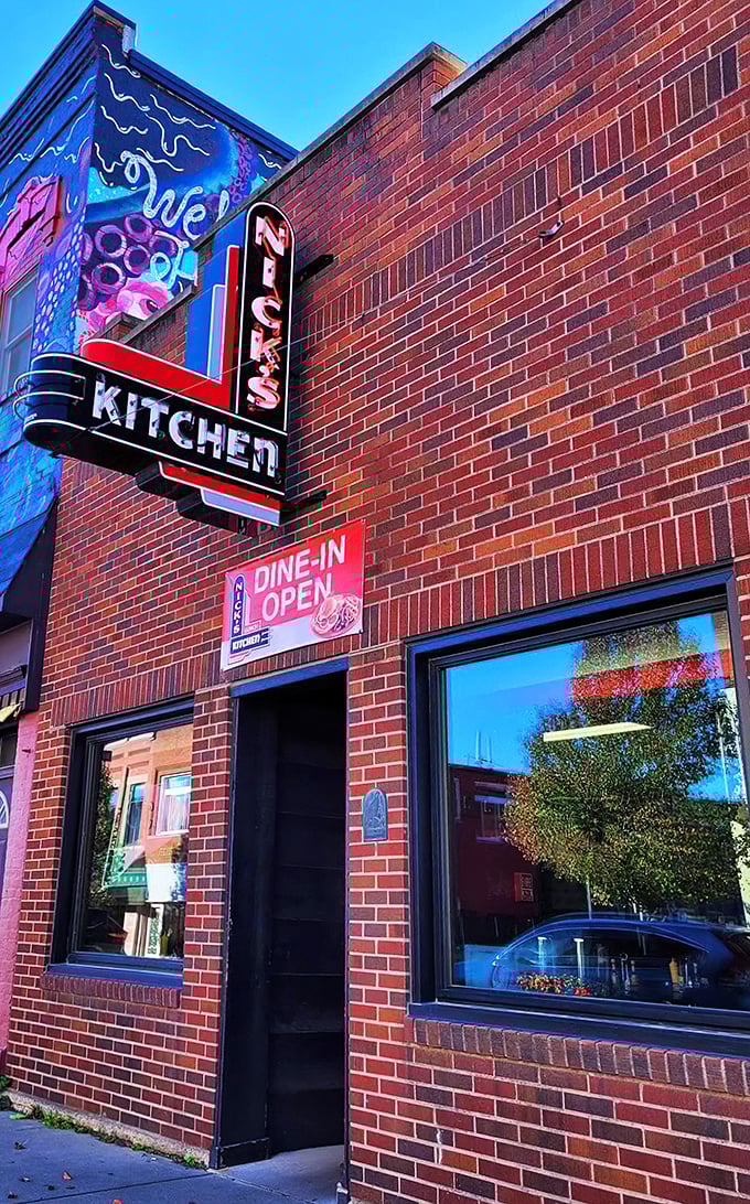 The iconic neon sign of Nick's Kitchen stands as a beacon of culinary history on Huntington's Jefferson Street. A century of tenderloin tradition lives behind this brick fa&ccedil;ade.