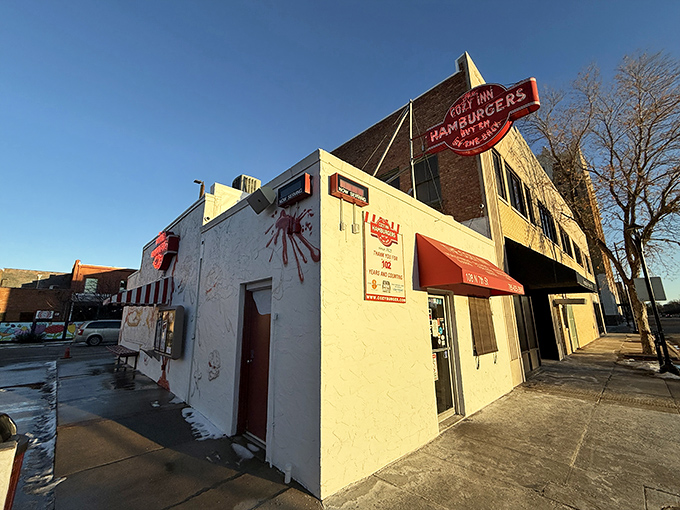The humble white facade of Cozy Inn, where culinary magic has happened since the Roaring Twenties. "Don't fear the smell, the fun is inside!"