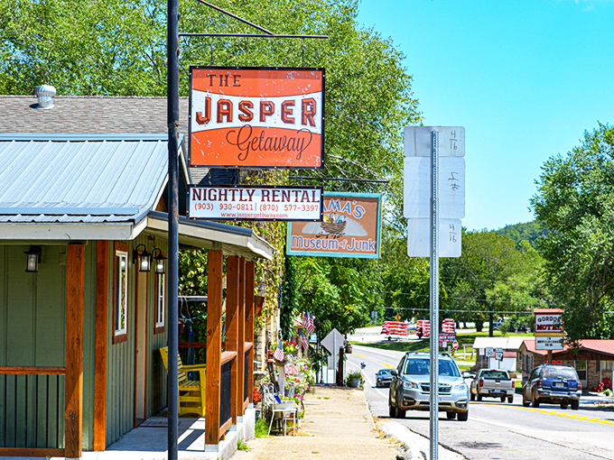 The Jasper Getaway sign welcomes visitors with a splash of orange against the Ozark backdrop – small-town charm with big-time views awaits.