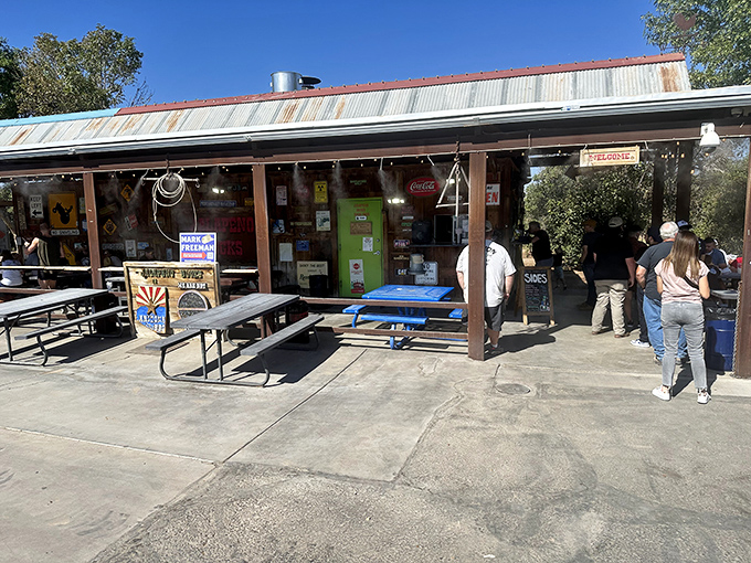 The rustic roadside charm of Jalapeño Buck's beckons hungry travelers with its weathered metal roof and promise of smoky delights ahead.