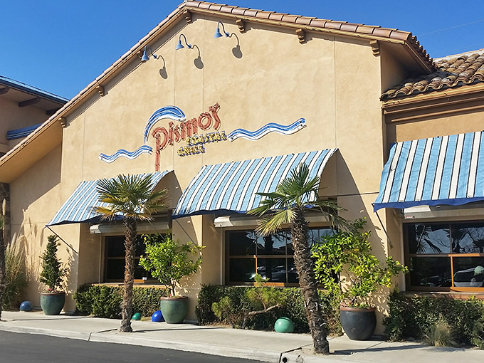 Pismo's terra cotta exterior with distinctive blue awnings stands like a coastal mirage in Fresno's urban landscape. Beach vibes without the sand in your shoes!