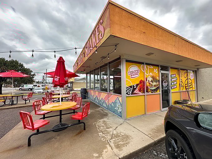 The sunshine-yellow exterior of Big Sky Burger stands out like a beacon for hungry travelers, promising simple pleasures with its no-nonsense "BURGERS &bull; FRIES &bull; SHAKES" declaration.
