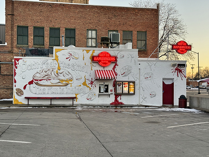 The humble white facade of Cozy Inn, where culinary magic has happened since the Roaring Twenties. "Don't fear the smell, the fun is inside!"
