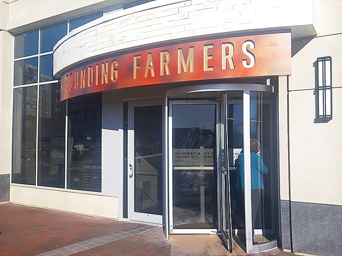 The welcoming entrance to MoCo's Founding Farmers beckons with its distinctive curved awning and warm wooden accents. Farm-to-table paradise awaits!