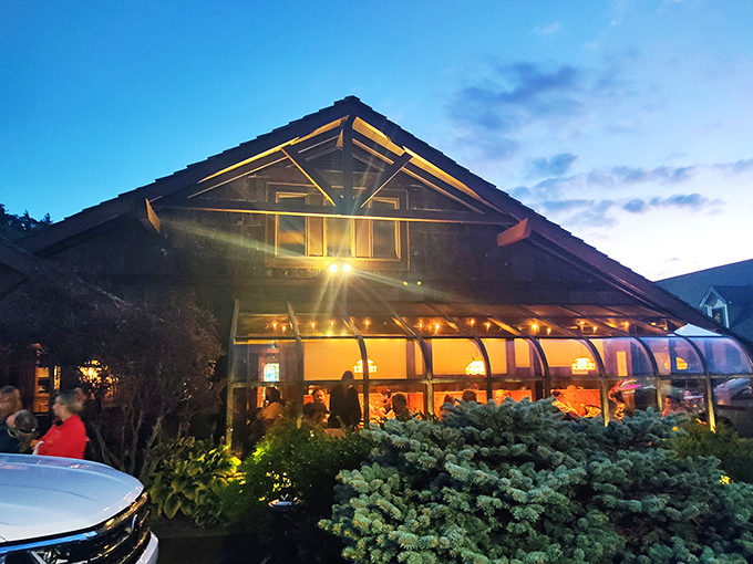 The iconic Peddler sign welcomes hungry travelers with its warm glow and glass-enclosed fire feature&mdash;a beacon of promised culinary delights in Boone's mountain landscape. 