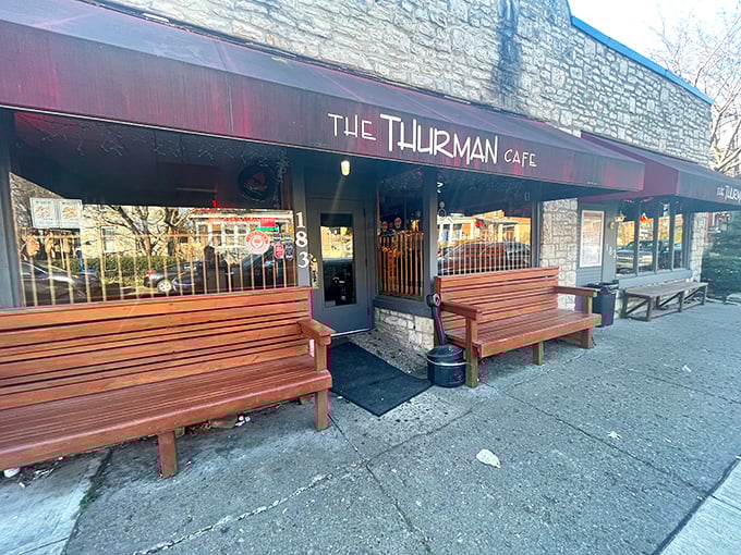 The unassuming stone exterior with its crimson awning doesn't scream "burger legend," but the wooden benches outside hint at something worth waiting for.