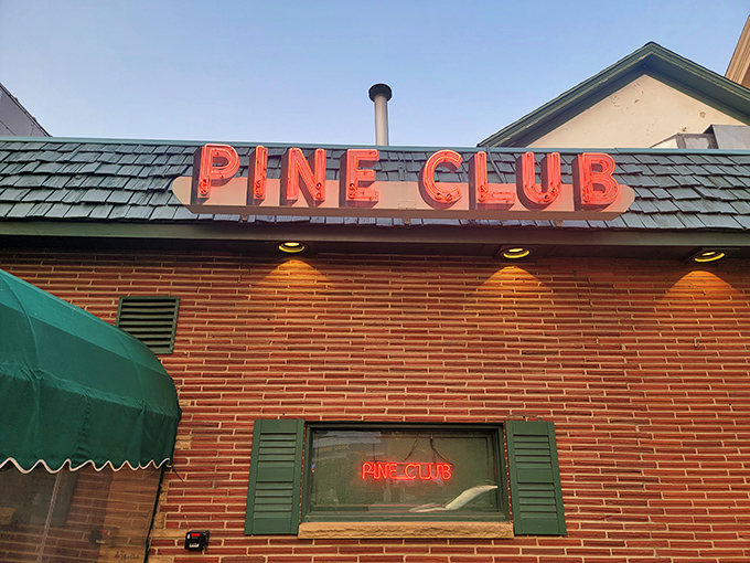 The iconic red neon sign beckons hungry diners like a lighthouse guiding ships to safe harbor. Pure steakhouse magic awaits.