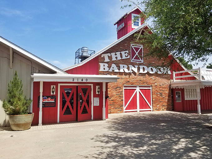 The iconic red barn facade beckons hungry travelers like a carnivorous lighthouse guiding you to beef paradise.