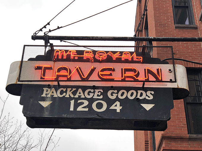 The iconic neon sign beckons like a lighthouse for thirsty souls, promising refuge and revelry at Baltimore's beloved Mt. Royal Tavern.