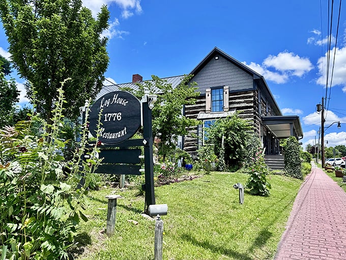 The Log House 1776 stands proudly in Wytheville, its weathered wooden exterior telling stories of centuries past while flowering wisteria adds a touch of romance.