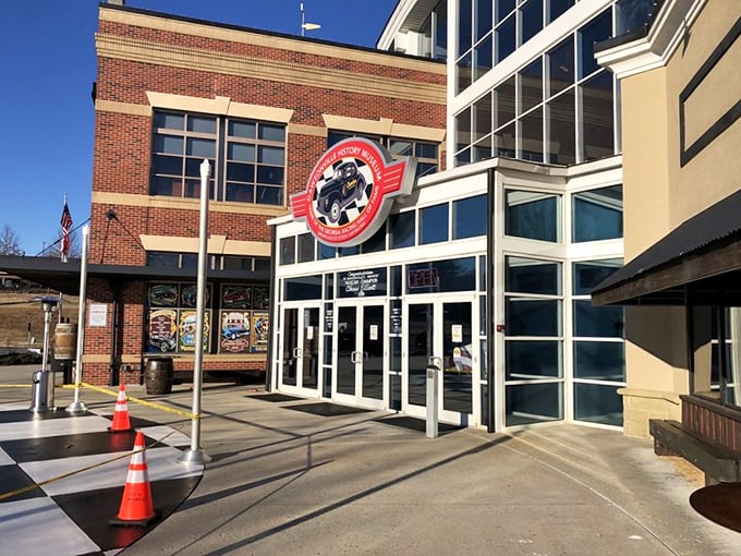 The checkered plaza welcomes speed enthusiasts like a starting line, with the sleek museum fa&ccedil;ade promising treasures that would make any gearhead's heart race faster than a qualifying lap.