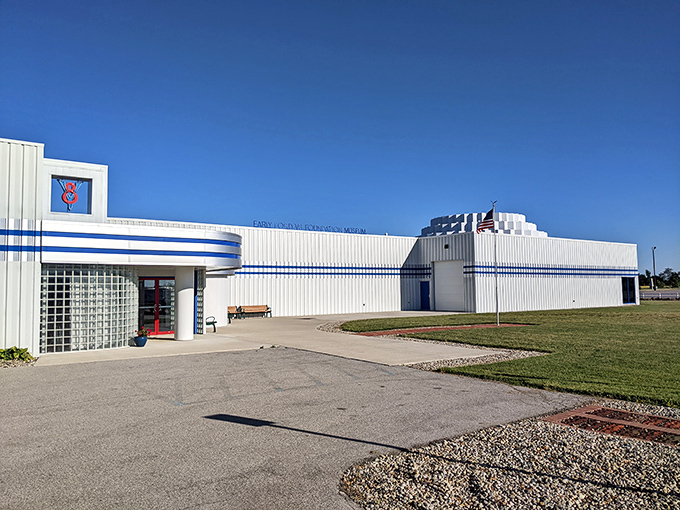 The sleek Art Deco-inspired exterior of the Early Ford V-8 Museum beckons car enthusiasts with its distinctive blue striping and retro styling. Automotive heaven awaits.