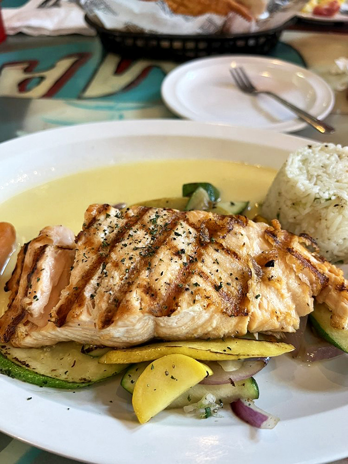 Perfectly grilled salmon atop seasonal vegetables&mdash;the dish that convinces health-conscious friends to join your seafood adventure.