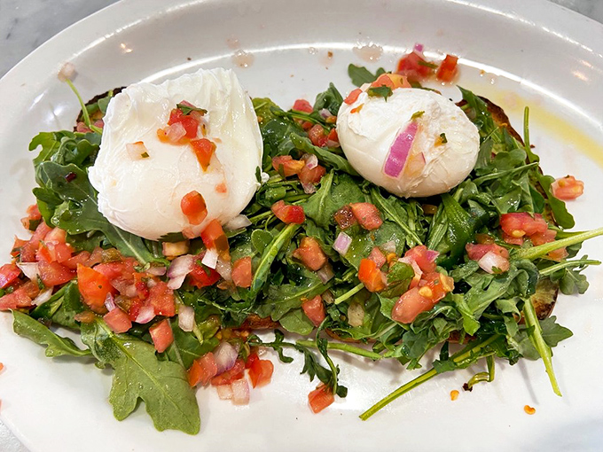 Poached eggs lounging on a bed of arugula like they're at a spa retreat. This dish is what happens when health food gets a personality.