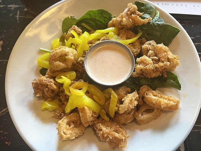 These golden calamari rings nestled on fresh greens aren't just appetizers &ndash; they're the opening act to a culinary concert.