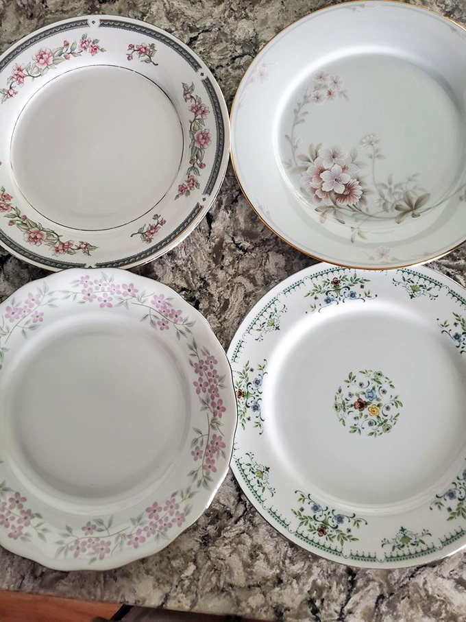 Delicate floral patterns on vintage china plates whisper of Sunday dinners and special occasions, each ready for a new home's celebrations.