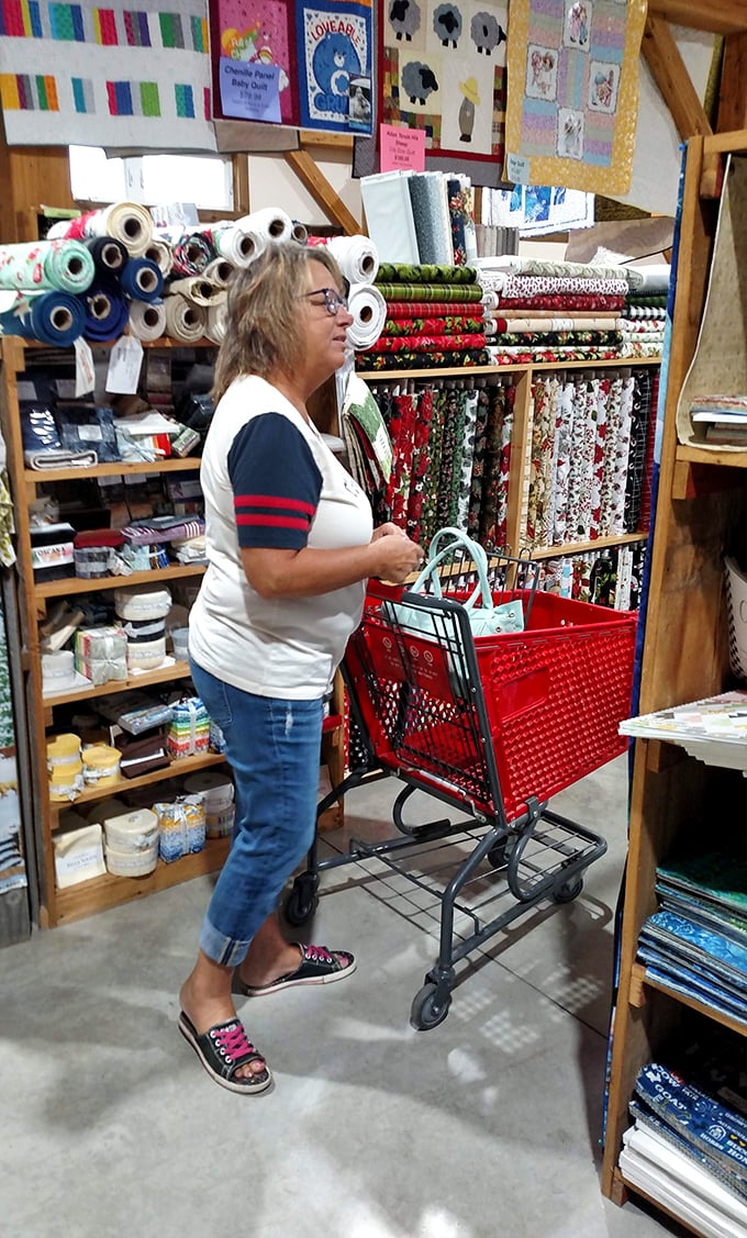Shopping becomes a treasure hunt as this customer navigates the fabric maze with her red cart, the universal sign of crafting commitment.