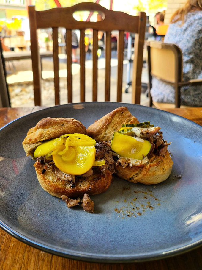 These biscuit sandwiches aren't just served, they're presented. The bright yellow pickles add a pop of color that says, "Yes, this is worth the Instagram moment."