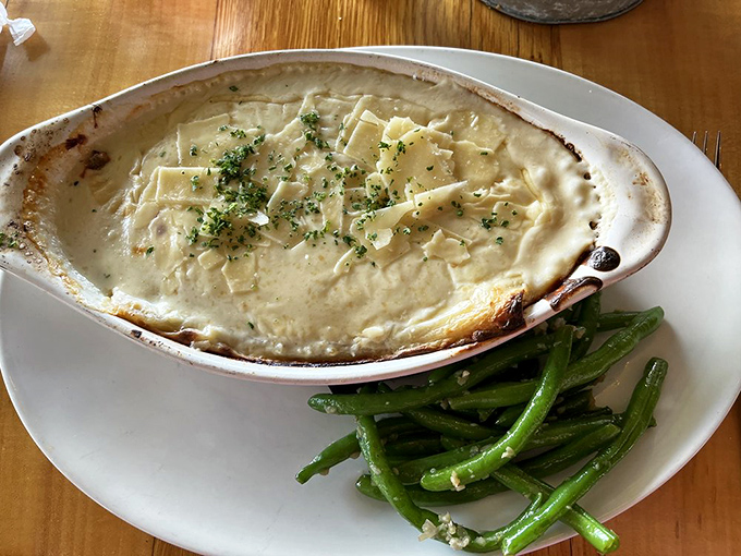 Seafood manicotti swimming in creamy sauce with green beans standing by&mdash;like comfort food went to culinary school and graduated with honors.