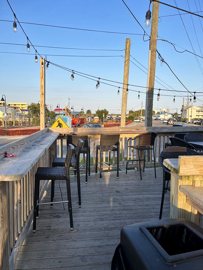 The back patio offers ocean breezes with your burger feast. String lights await sunset, promising casual coastal magic.