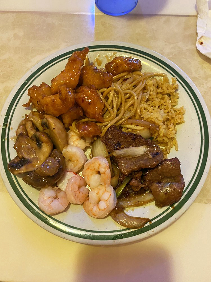 A symphony of textures and flavors: tender beef, succulent shrimp, and sweet-glazed chicken sharing plate space in perfect harmony.