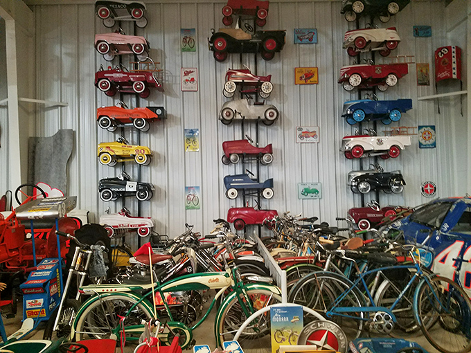The wall of pedal cars and vintage bicycles showcases childhood dreams from an era when imagination provided the horsepower.