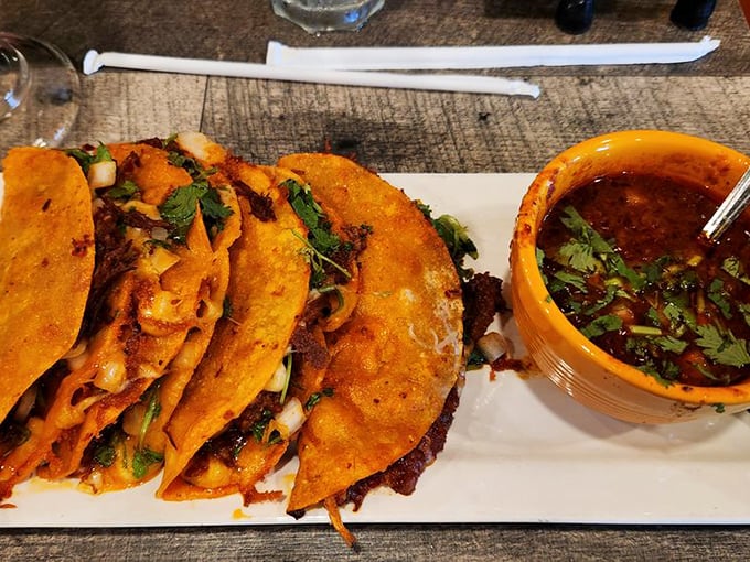 Crispy birria tacos with that essential side of consomm&eacute;&mdash;like getting the director's cut version of your favorite culinary blockbuster.