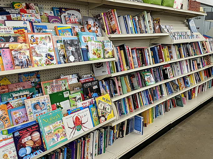 Children's books line up like colorful soldiers of imagination. Spot "God's Gift" next to "Nursery Rhymes"—something for every young mind.
