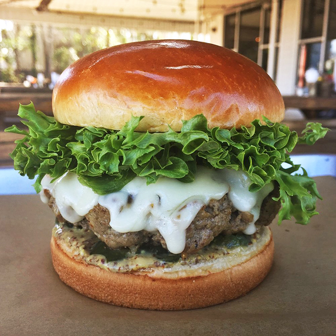 The burger that launched a thousand road trips. That melty cheese and fresh lettuce create the perfect backdrop for the star attraction