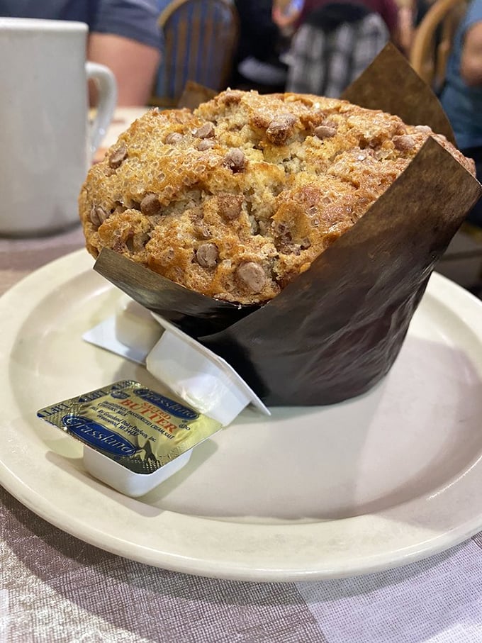 This muffin doesn't just rise—it reaches for the heavens, with a paper wrapper barely containing its ambitions and butter-laden glory.