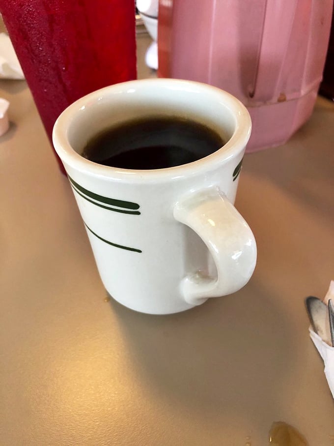 The humble diner coffee mug &ndash; holding the elixir that transforms morning zombies into functioning humans one sip at a time.
