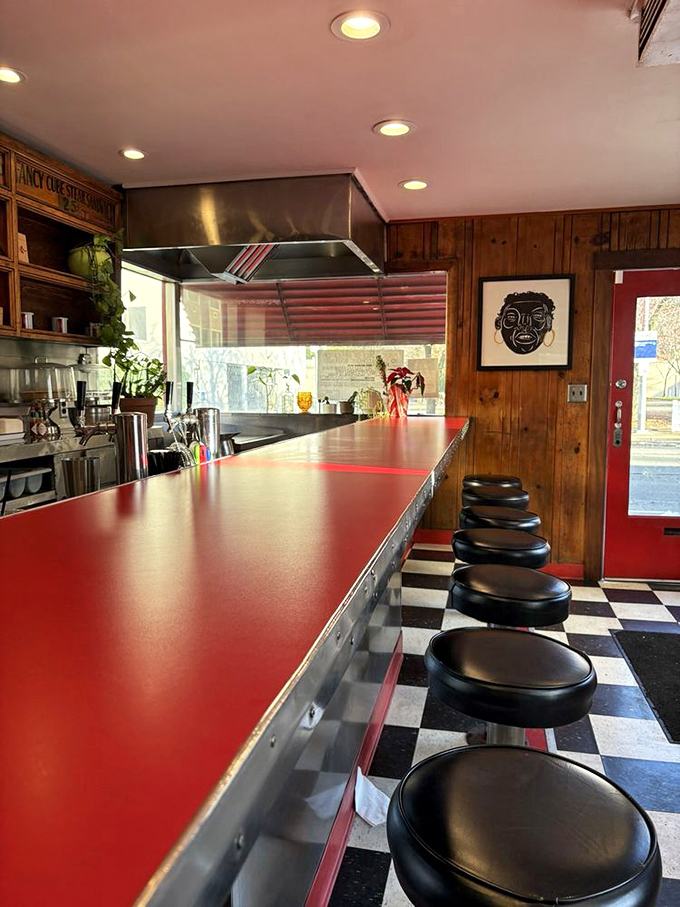 The red counter with black stools against checkerboard floors&mdash;a diner aesthetic so perfect it could be a movie set.