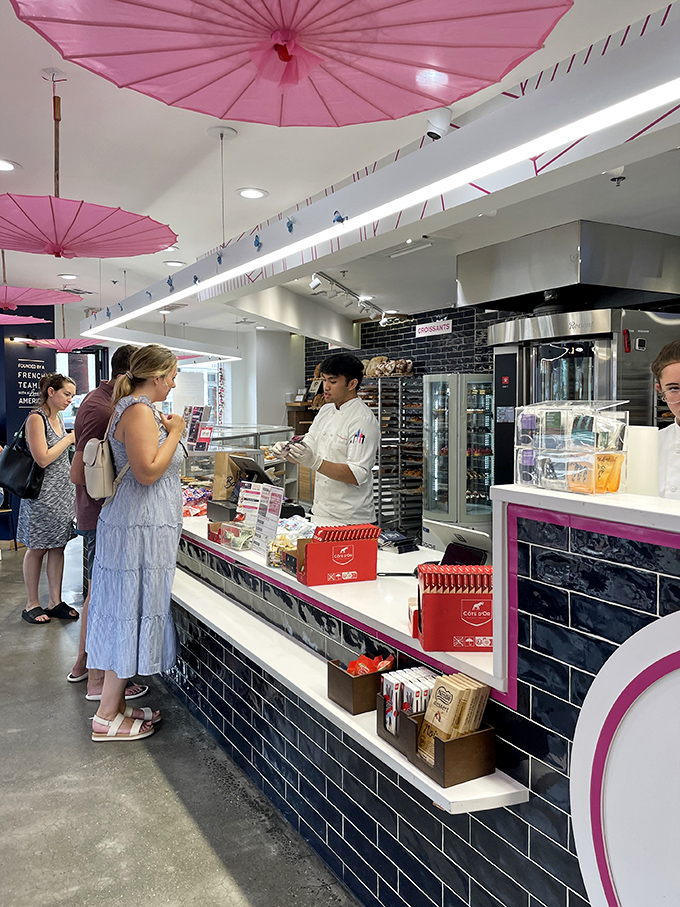 Under whimsical pink parasols, customers patiently wait for their French-inspired treasures &ndash; some pleasures are worth standing in line for.