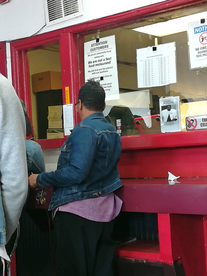 The sign says it all: "We are not a fast food restaurant." Good things come to those who wait, and these customers know the payoff is worth every minute.