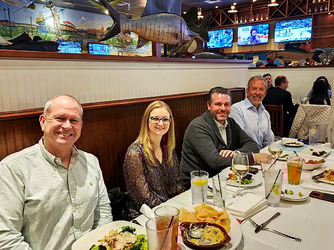 Happy diners gathered beneath mounted fish&mdash;the circle of life in restaurant form. Those smiles suggest the food lives up to the decor.