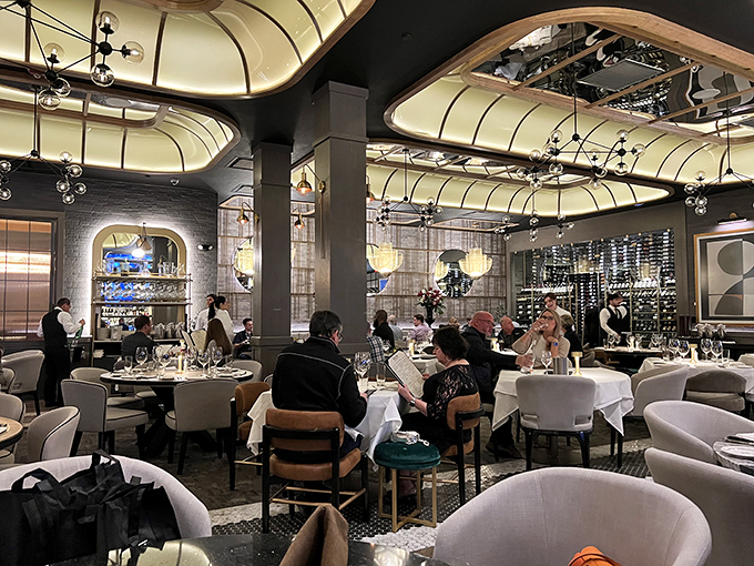 White-jacketed servers glide between tables with practiced precision, part of the choreography that elevates dinner to an experience.