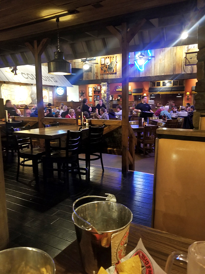 Families gather in the warm glow of wood-paneled walls, united by the universal language of good food and conversation.