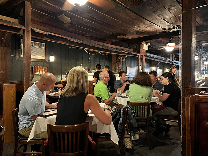 Diners lean in over white tablecloths, engaged in that universal body language that says, "I might share conversation, but not what's on my plate."