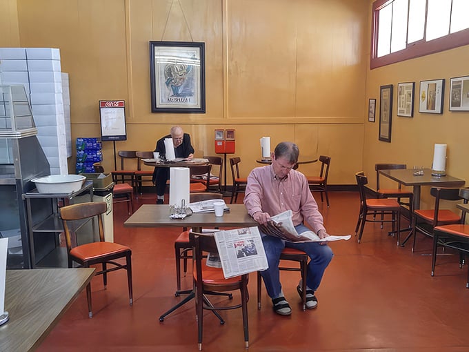 The morning ritual&mdash;coffee, newspaper, and the gentle hum of conversation. These gentlemen know that some traditions are worth preserving, especially when donuts are involved.
