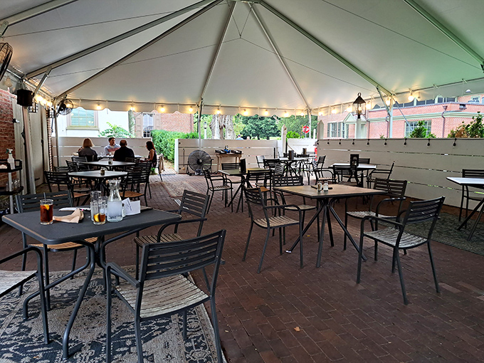 The outdoor dining area under a pristine white tent feels like the most civilized picnic you've ever attended. Fresh air with a side of history.