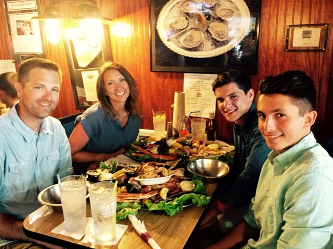 Happy diners diving into a seafood feast. This spread looks so good, it could make Aquaman consider giving up his trident for a fork.