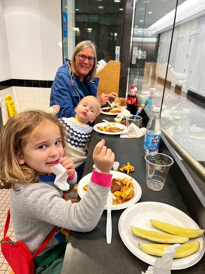 Three generations of deli devotion in one frame&mdash;passing the sandwich tradition down like a cherished family heirloom.