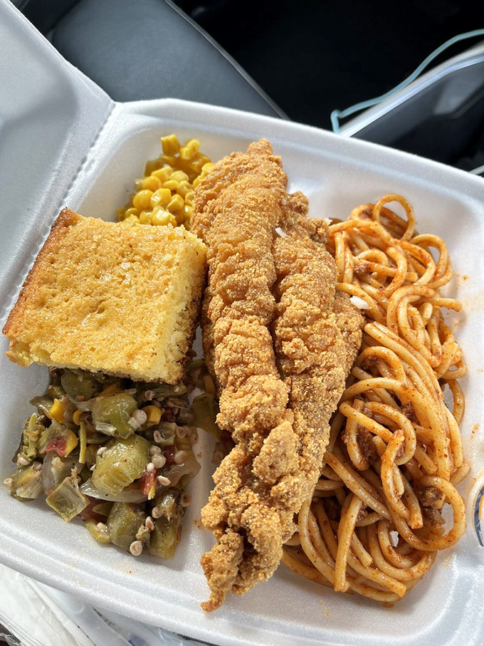 A feast fit for royalty: golden catfish, saucy spaghetti, farm-fresh vegetables, and cornbread&mdash;proof that true luxury comes in styrofoam containers.