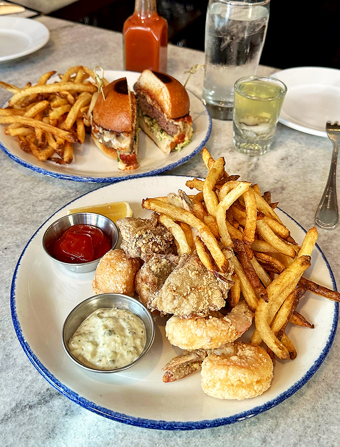 The fried seafood platter with dual dipping sauces – because important decisions shouldn't be forced upon hungry people. Golden, crispy perfection.