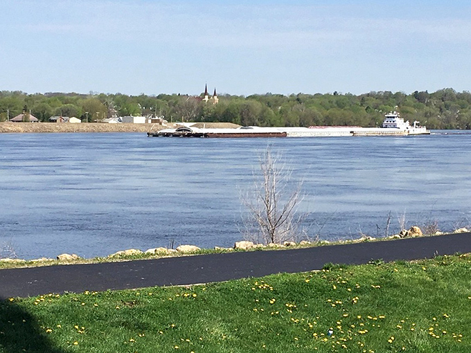 The mighty Mississippi carries barges past Fulton's shoreline, a watery highway that's been in business longer than Amazon Prime.