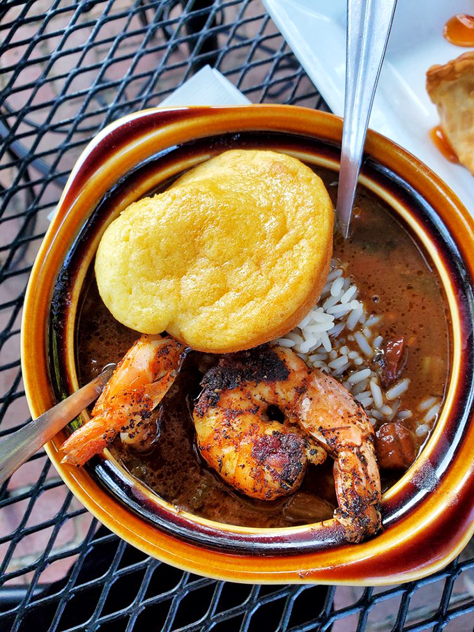 A bowl of gumbo that's practically a history lesson in Louisiana cuisine, complete with plump shrimp and a cornbread hat.