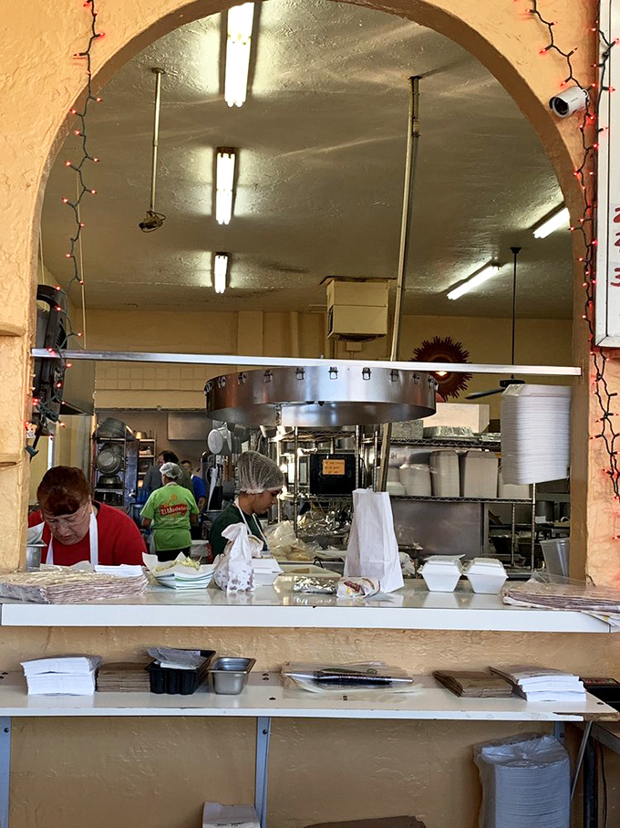 Through the kitchen archway, the magic happens. Those aren't just cooks—they're keepers of culinary traditions that define New Mexican cuisine.
