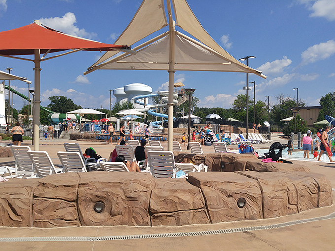Strategic shade umbrellas and lounge chairs &ndash; the adult version of claiming territory. The neutral Switzerland of the water park where parents recharge.