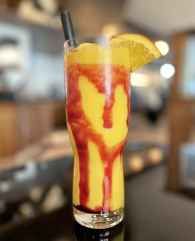 This sunrise-in-a-glass smoothie has layers like a good mystery novel. The dramatic red swirls against yellow create beverage theater worth the price of admission.